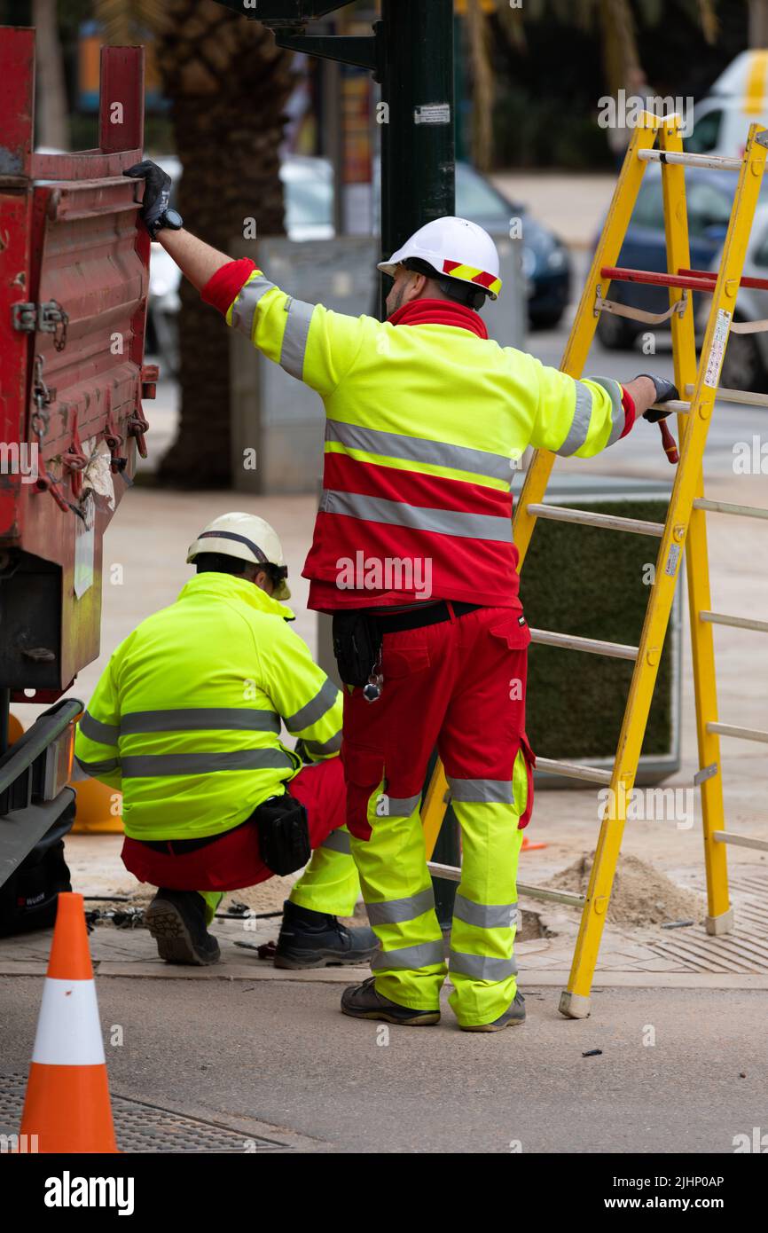 Two electrician worker fixing a traffic light in city street Stock ...