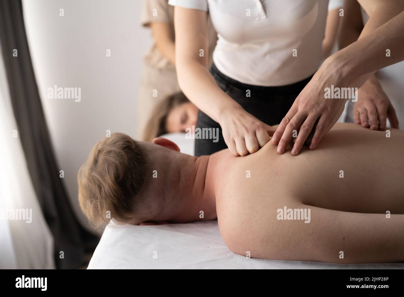 massage training. Man having massage in spa salon, closeup. masseuse massaging shoulders of a ...