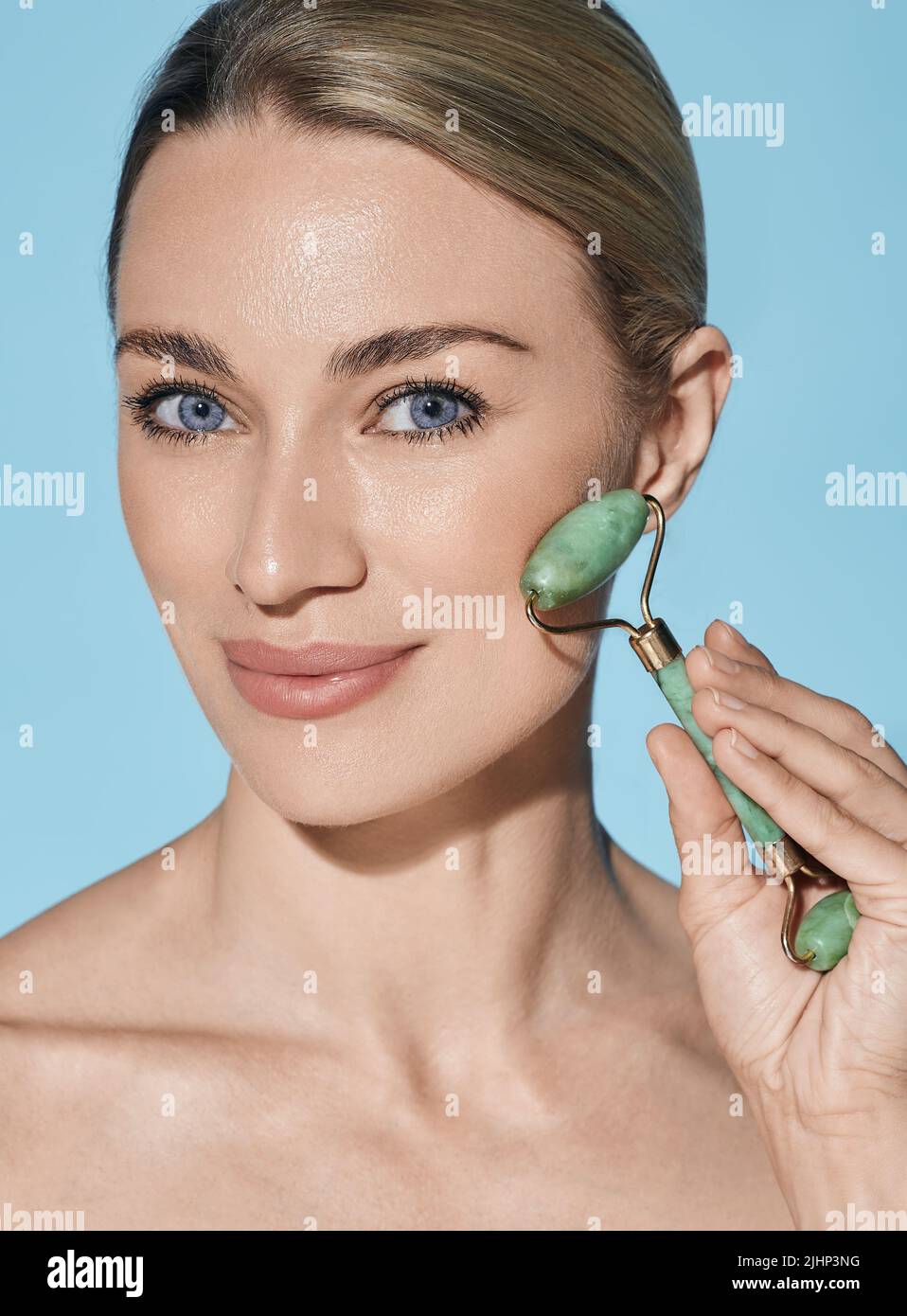 Face jade roller. Face of beautiful woman with green jade roller for ...