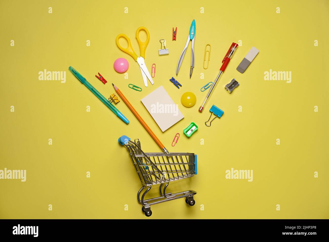 Trolley cart with school supplies on a yellow background. Flat, top ...