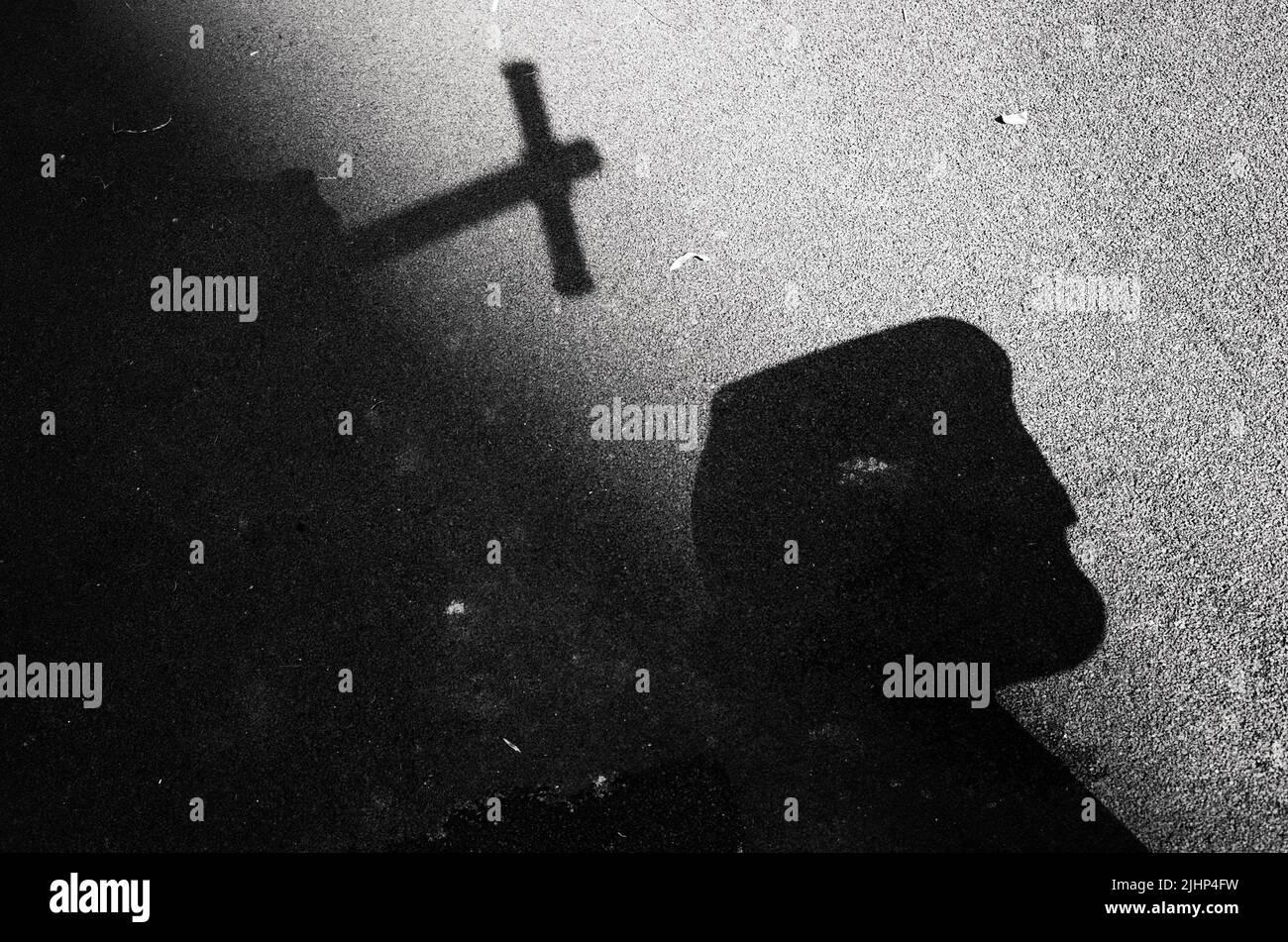 A shadow on the road in the form of a head and a cross Stock Photo - Alamy