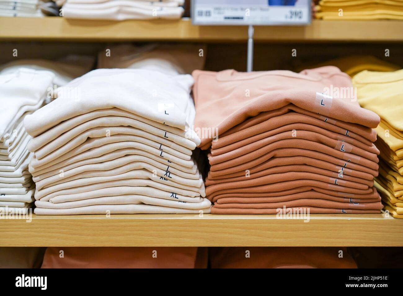 A pile of shirts, earth tone color, cream and brown was folded and put ...