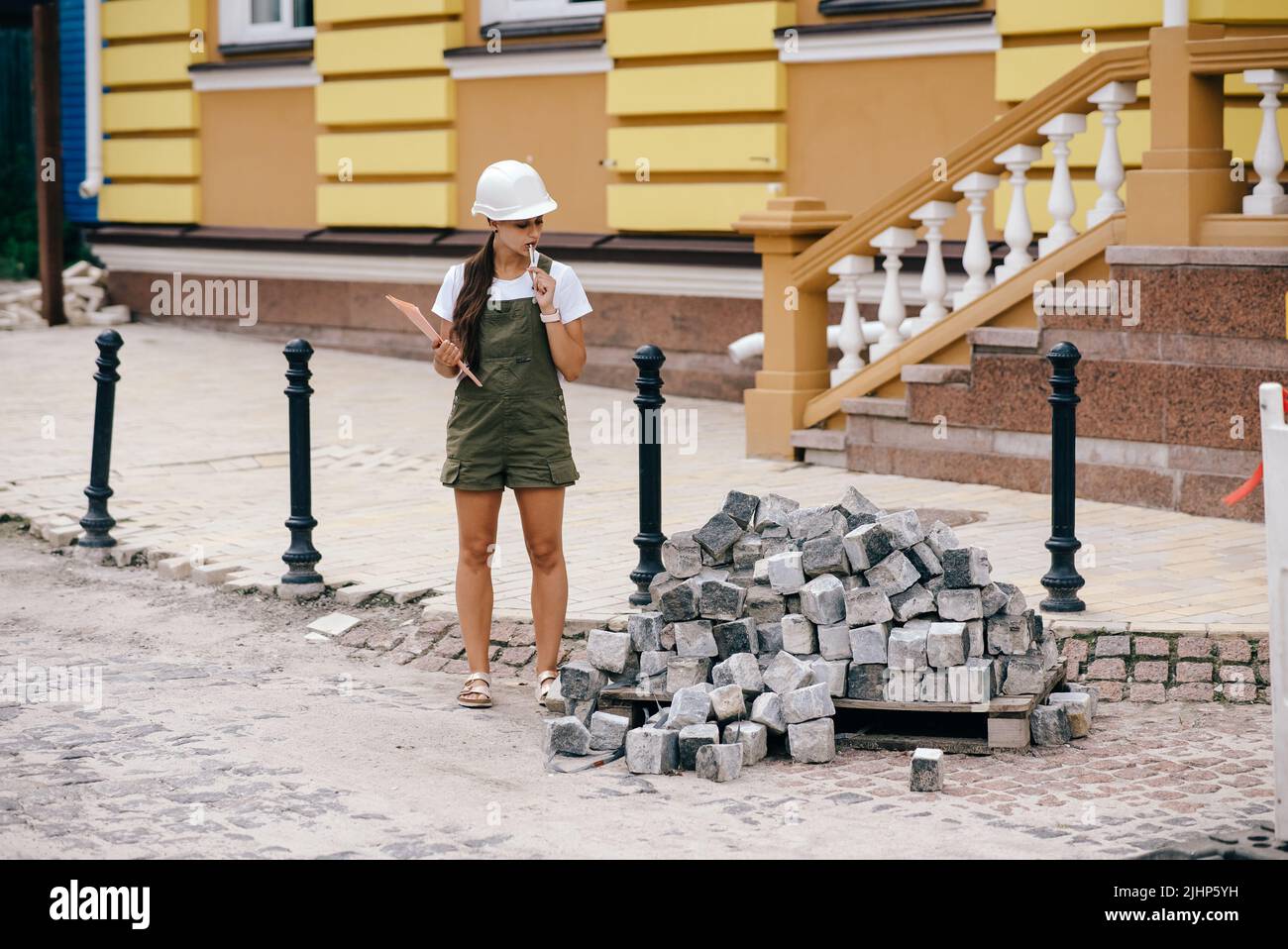Woman civil engineer counts building materials at a construction site ...