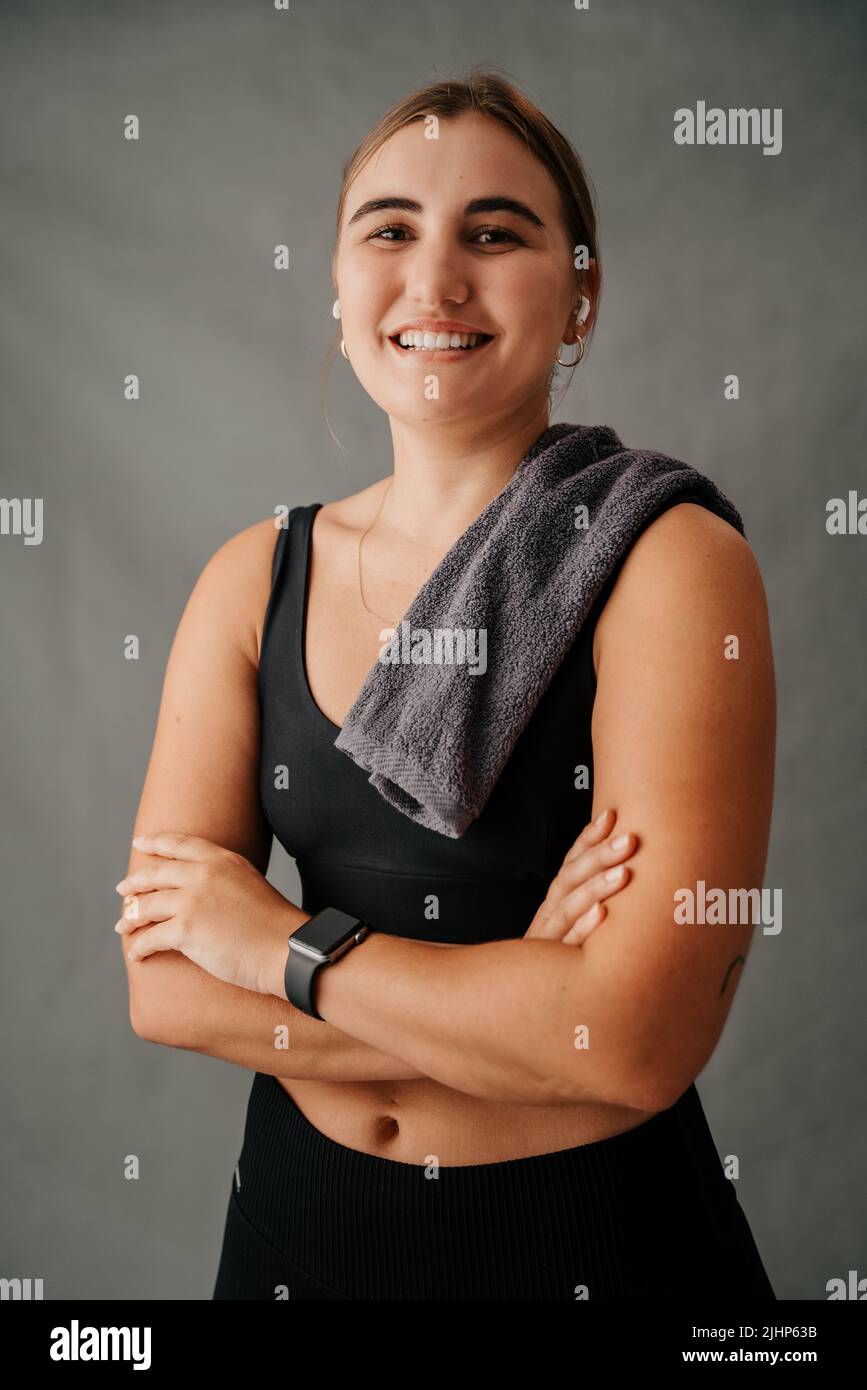 Close up young female smiling crossed arms and ready for work out ear ...