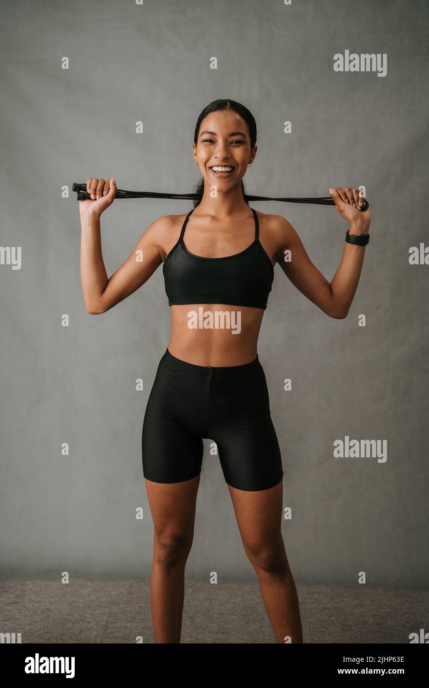 Multiethnic female holding her skipping rope getting ready for work out ...