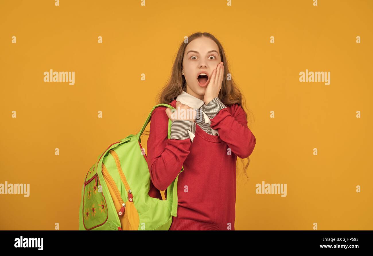 amazed kid with school backpack on yellow background, school Stock ...