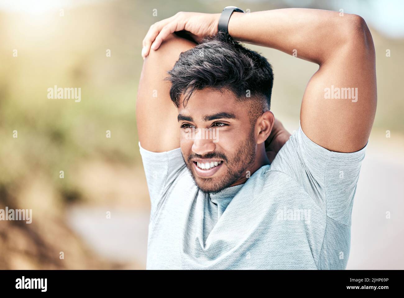 Fit young mixed race man stretching before his exercise outdoors ...