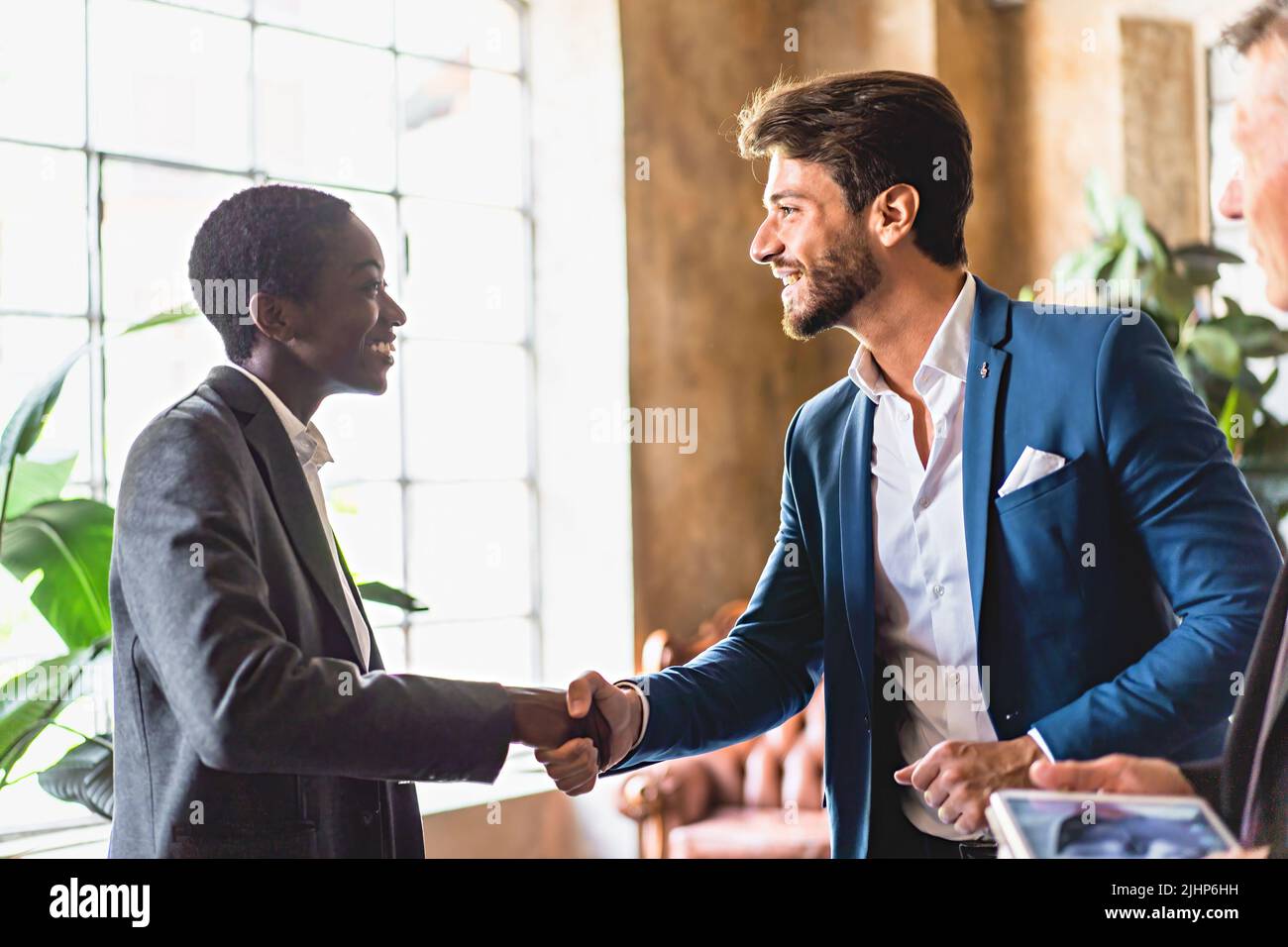 Multiethnic couple of business people handshake in the office ...
