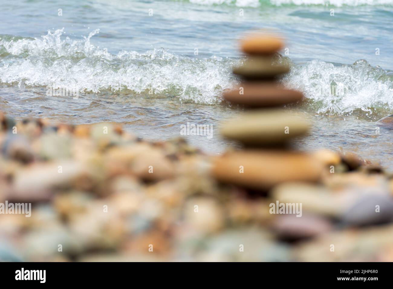 Close-up blurred pyramid stones balance on the beach. Calm. Zen-like ...