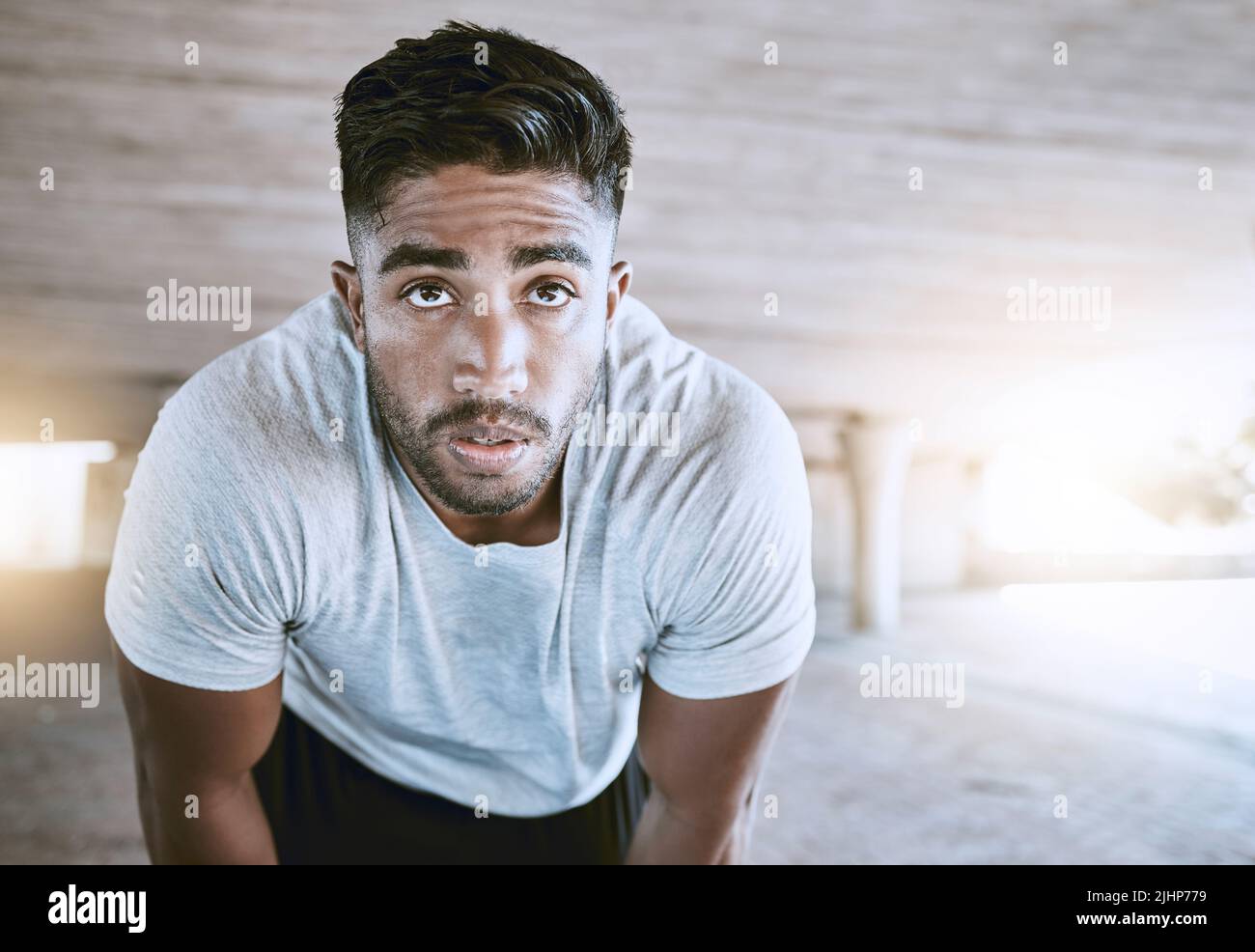Serious athlete taking break from workout. Young man getting ready to ...