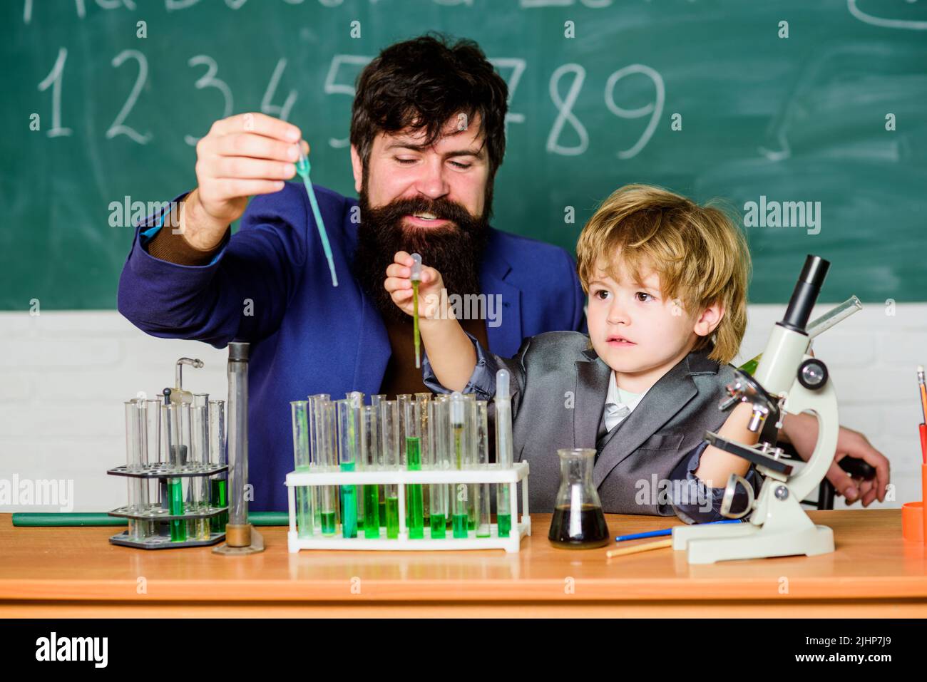 teacher man with little boy. school kid scientist studying science ...
