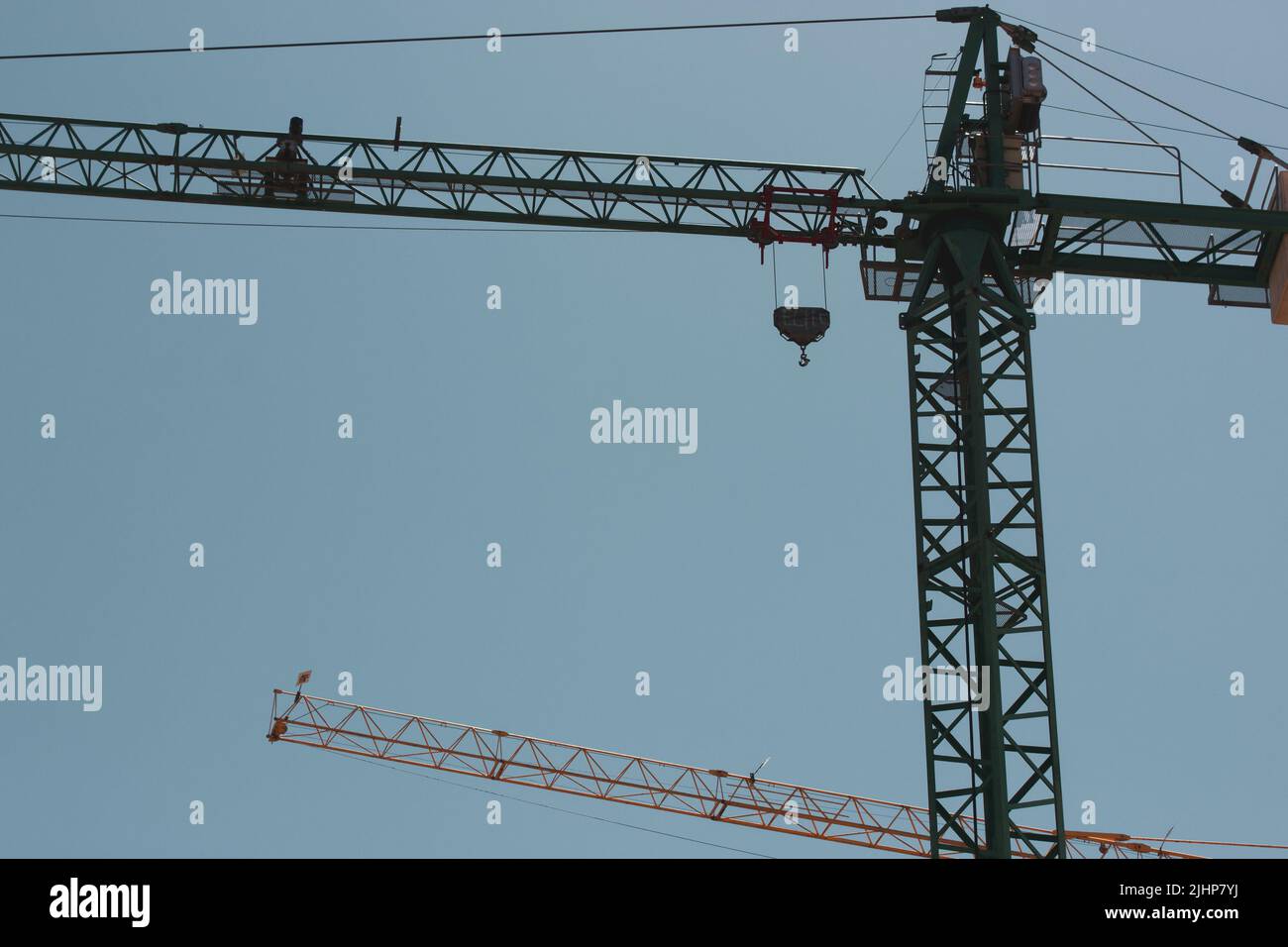 Construction cranes against blue sky view from below. Construction site ...