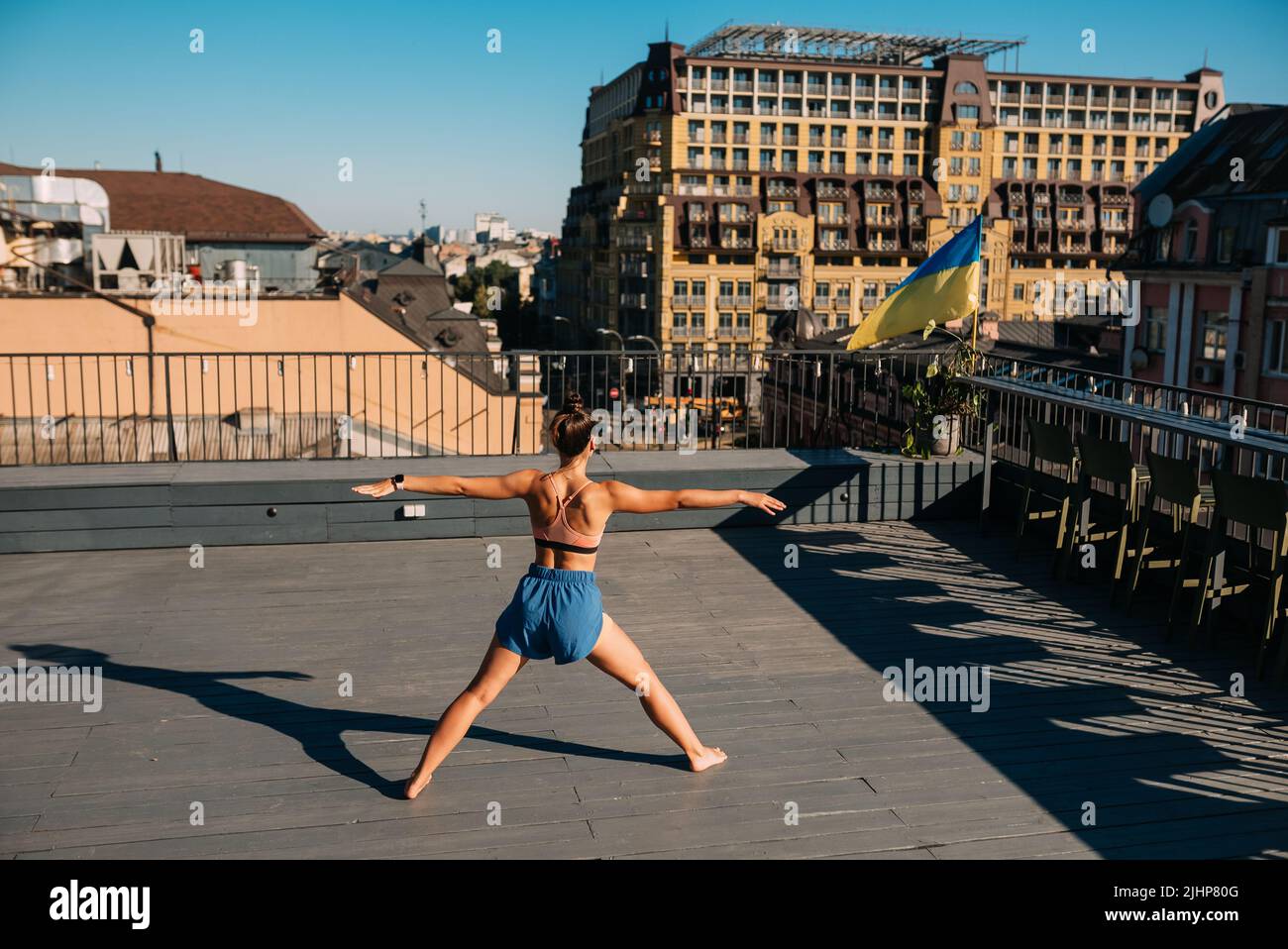Young woman practicing yoga on the roof of a building Stock Photo - Alamy