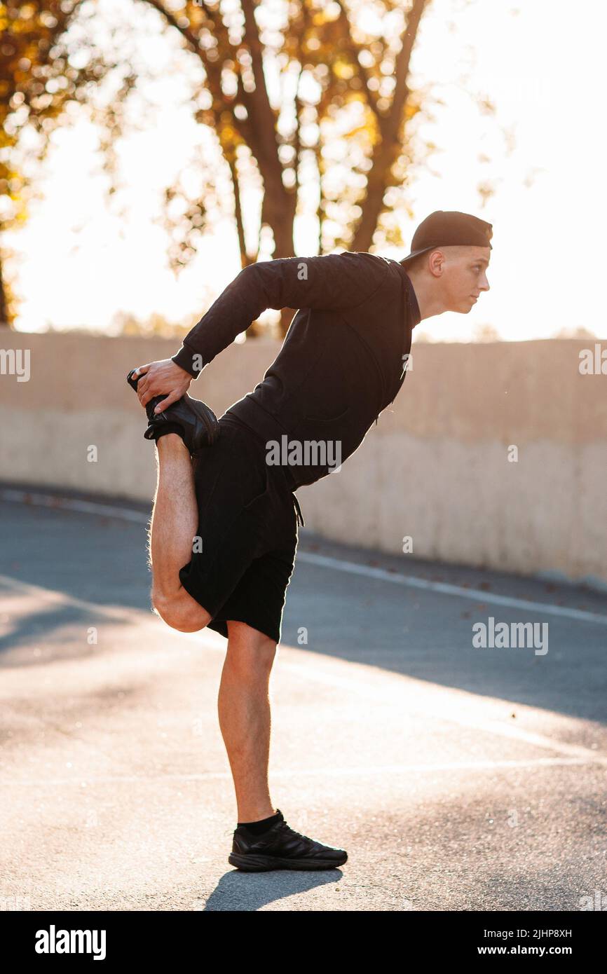Sprinter warming-up his legs before training Stock Photo - Alamy