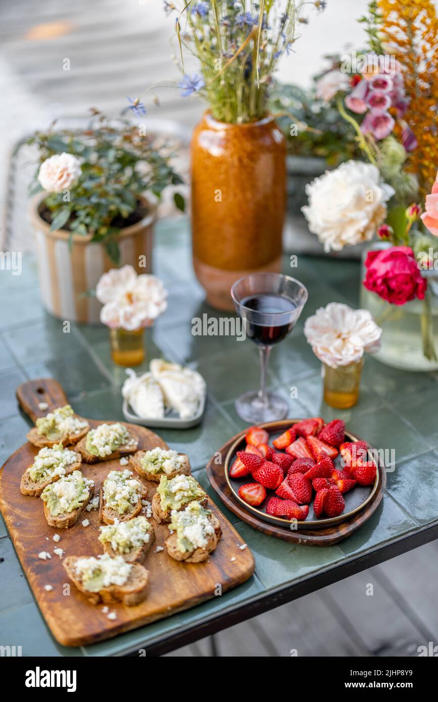 Delicious snack on garden table decorated with flowers Stock Photo - Alamy