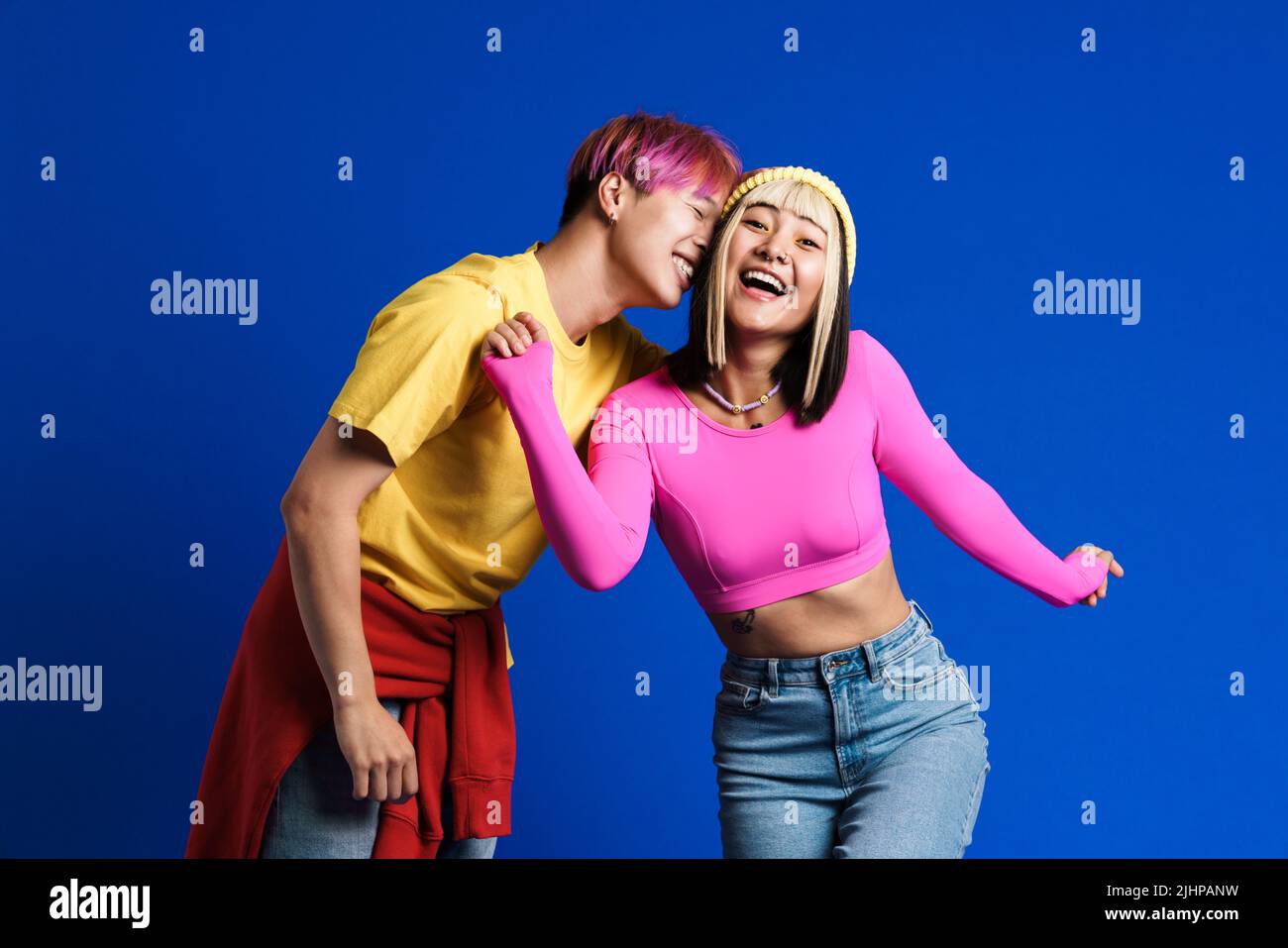 Asian couple with multicolored hair laughing and dancing together ...