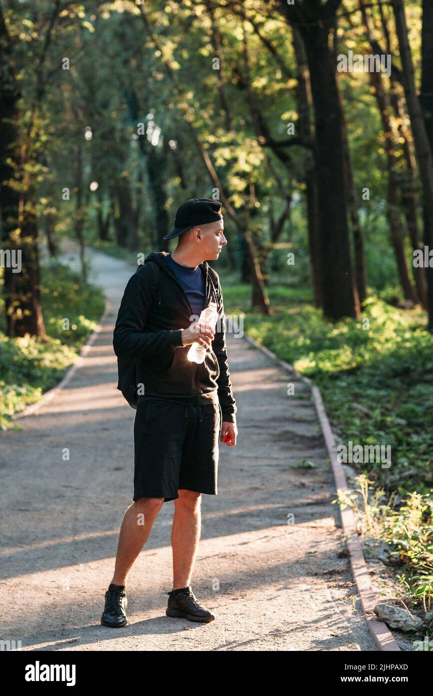 Hiker with bottle of water on forest trails Stock Photo - Alamy