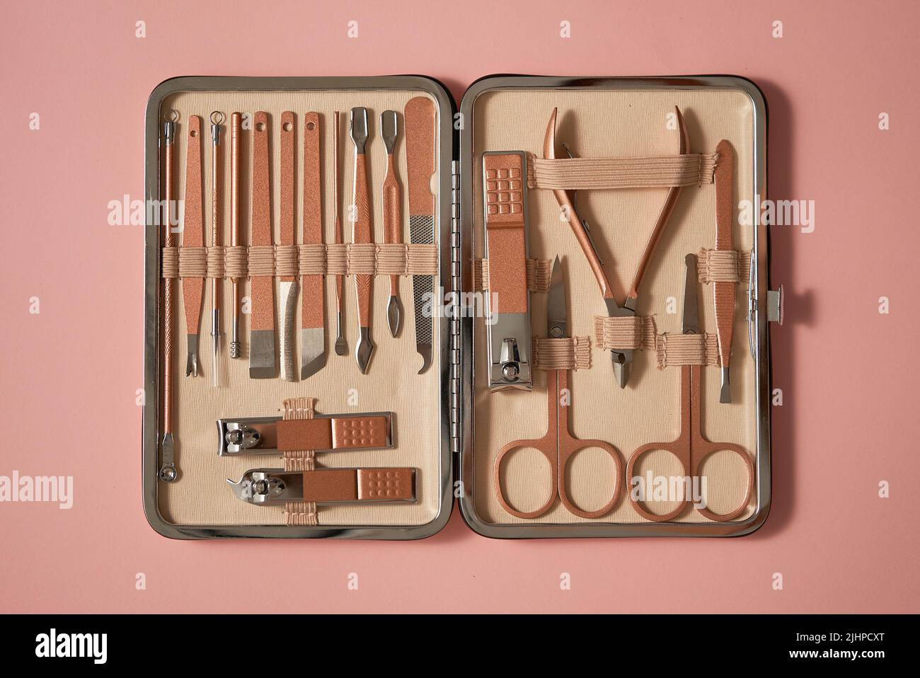 Pastel cosmetic set for nail care in a case placed on a pink background ...