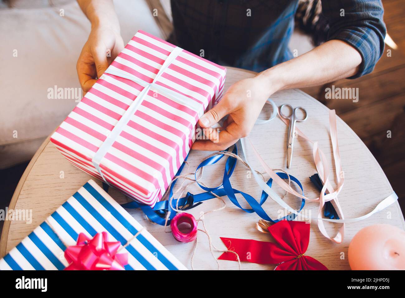 Creative craftsman decorating box with presents Stock Photo - Alamy