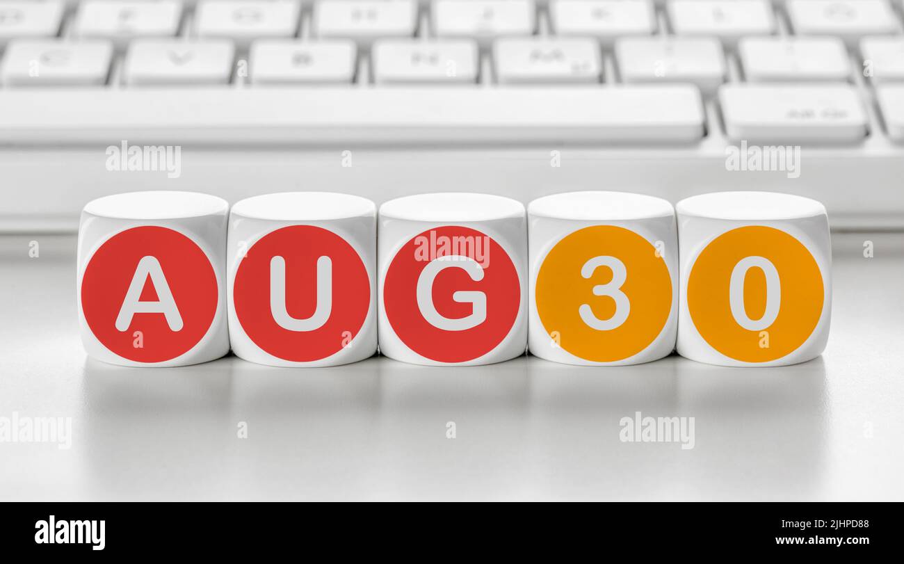 Letter dice in front of a keyboard - August 30 Stock Photo - Alamy