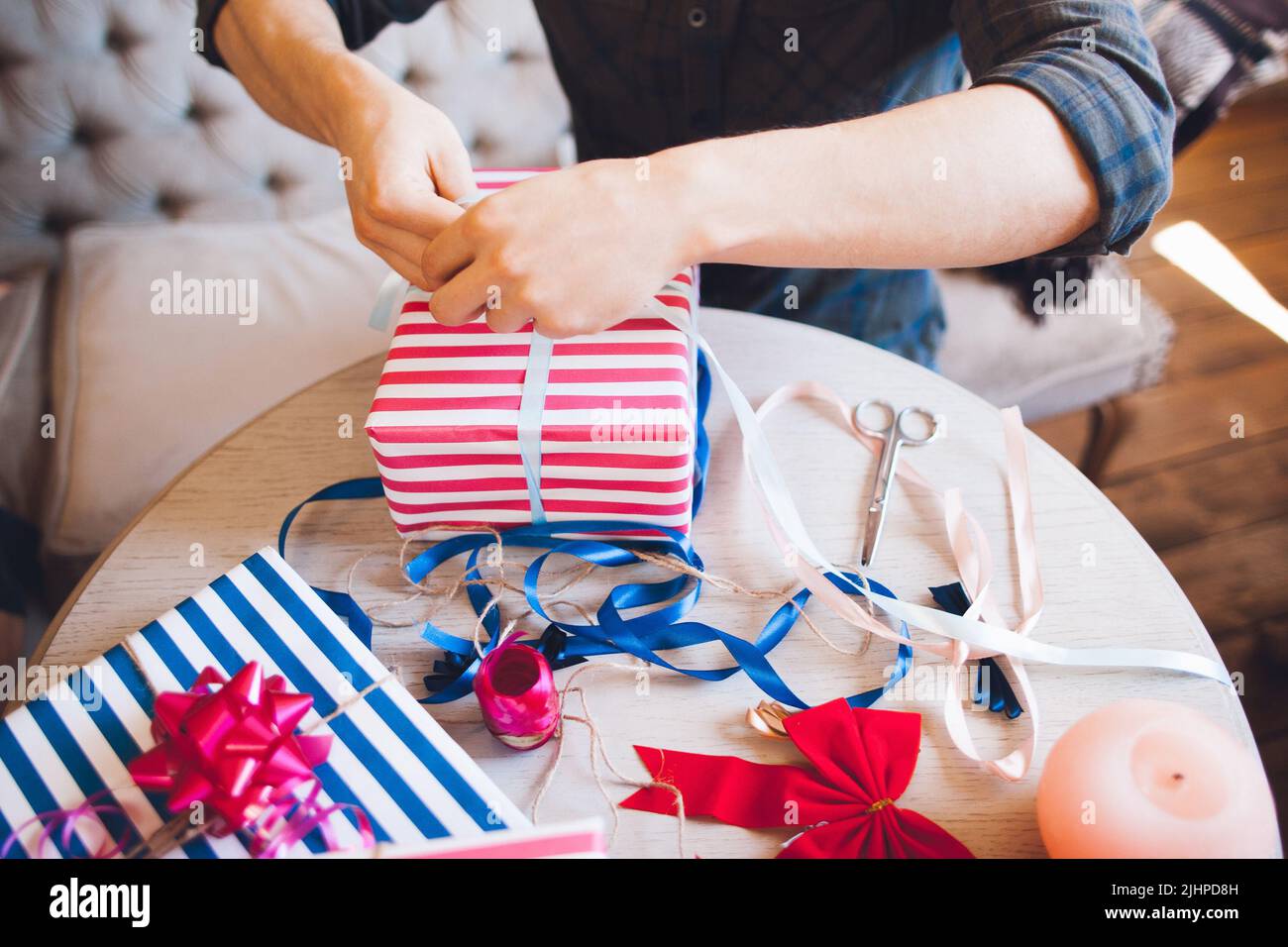 Man decorating present box with ribbon Stock Photo - Alamy