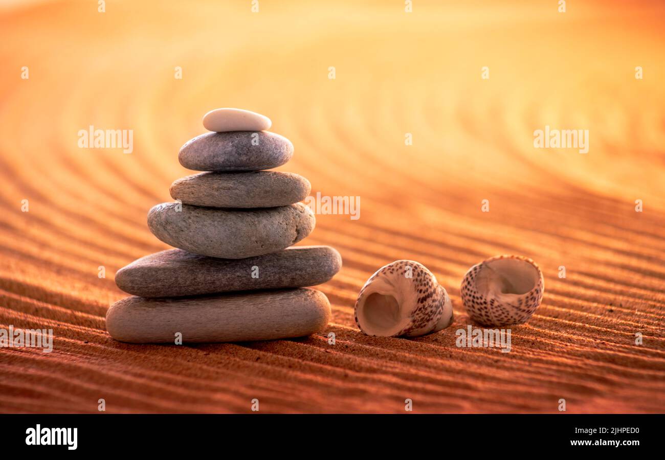 Stack of six zen stones in a relaxing sunset beach setting that invokes ...