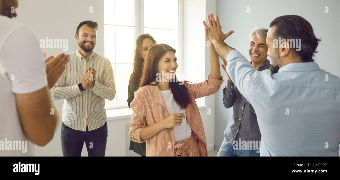 Happy man and woman giving each other high five during workshop with ...