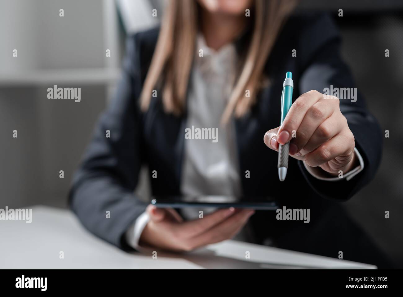 Businesswoman Holding Tablet In One Hand And Pointing With Pen On ...