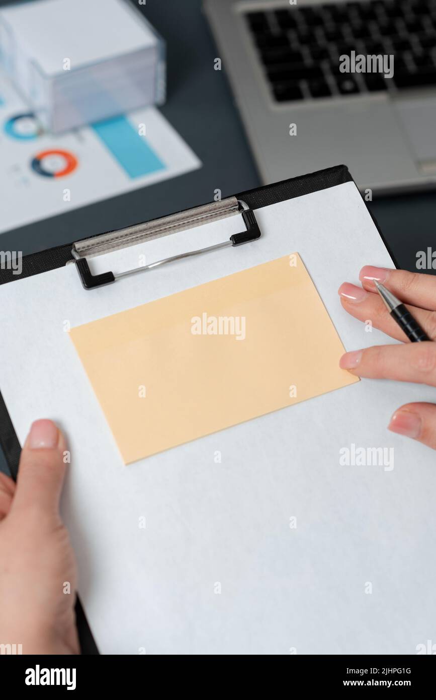 Businesswoman Holding Pen And Clipboard With Note On It With Important ...