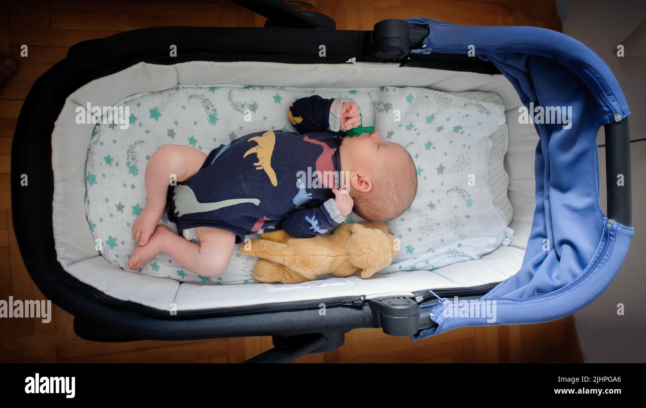 Cute little peaceful baby calm sleeps soundly in his baby carriage ...