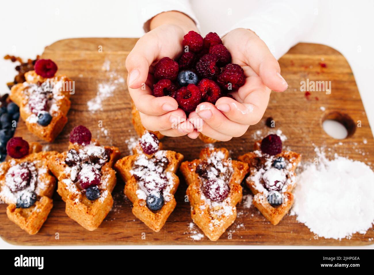Child hands full of fresh raspberry, top view Stock Photo - Alamy