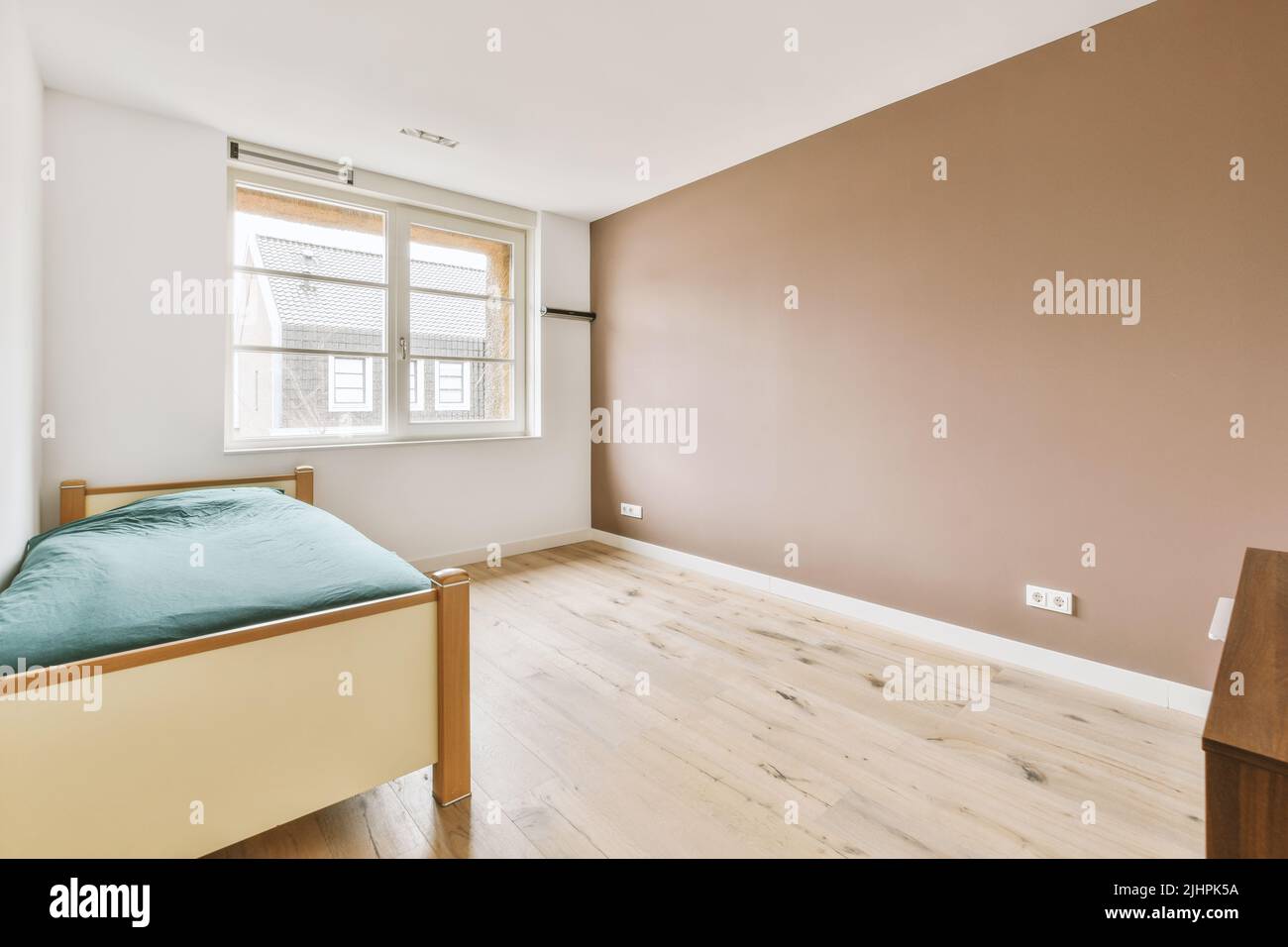 Comfortable bed without ornamental blanket, near window and wardrobe in ...