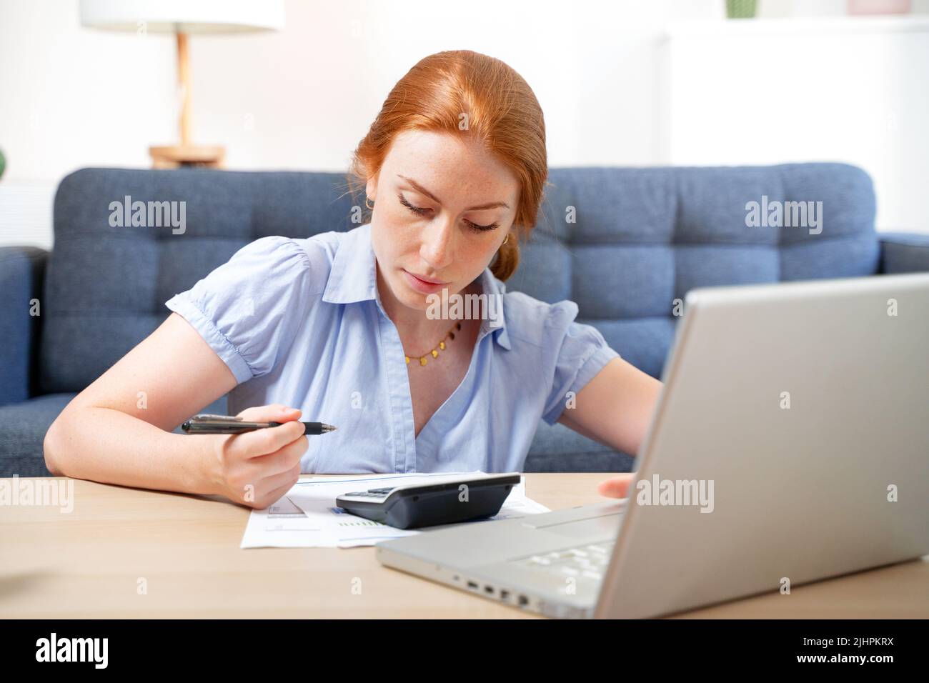 Woman working through papers and calculating home budget Stock Photo ...