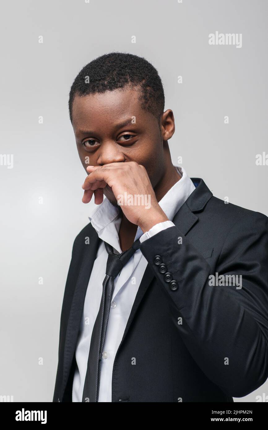 African american man closes mouth by left hand Stock Photo - Alamy