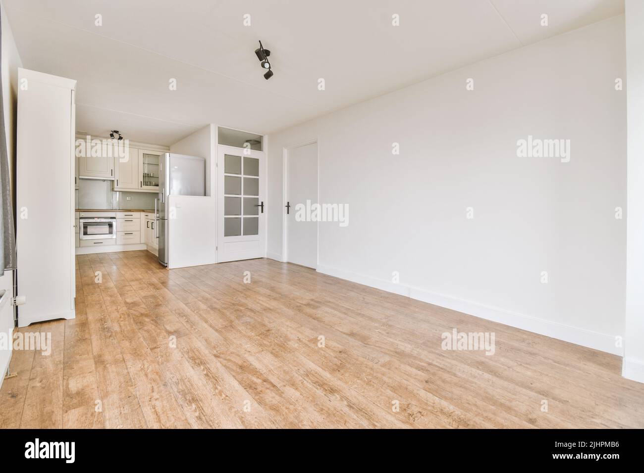 Interior of empty white kitchen with windows and wooden parquet floor ...