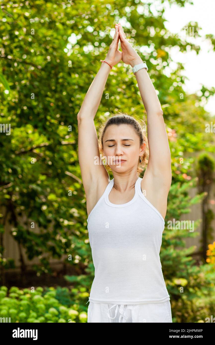 Young woman practices yoga in the summer garden - Namaskar Mudra Stock ...