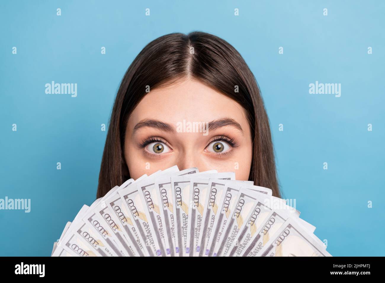 Portrait of attractive stunned rich girl hiding face behind us income ...