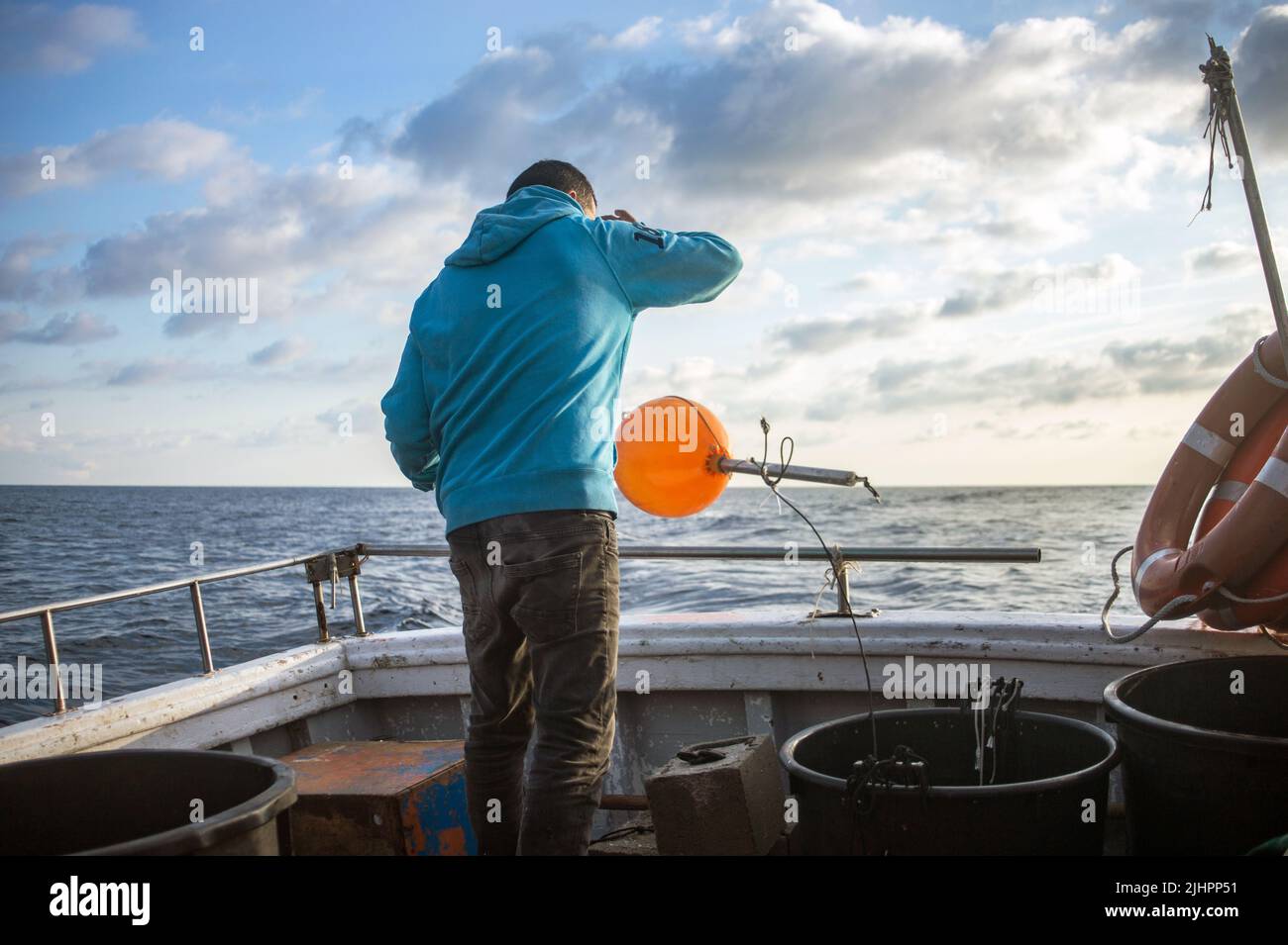 Fisherman pulling the line with hooks and buoys Stock Photo - Alamy