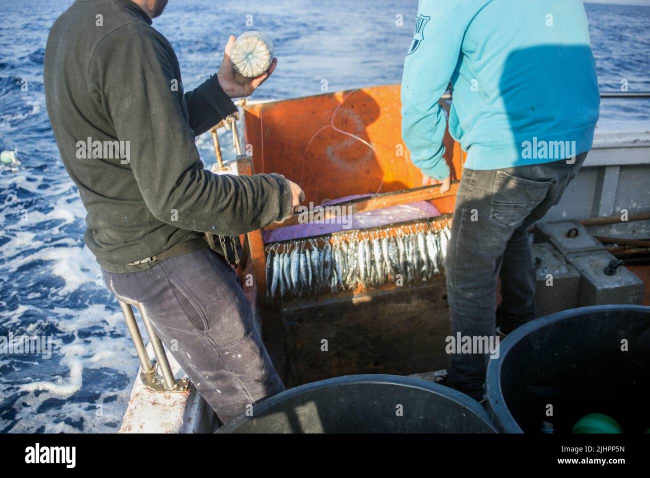 Fishermen pulling the line with hooks and buoys Stock Photo - Alamy