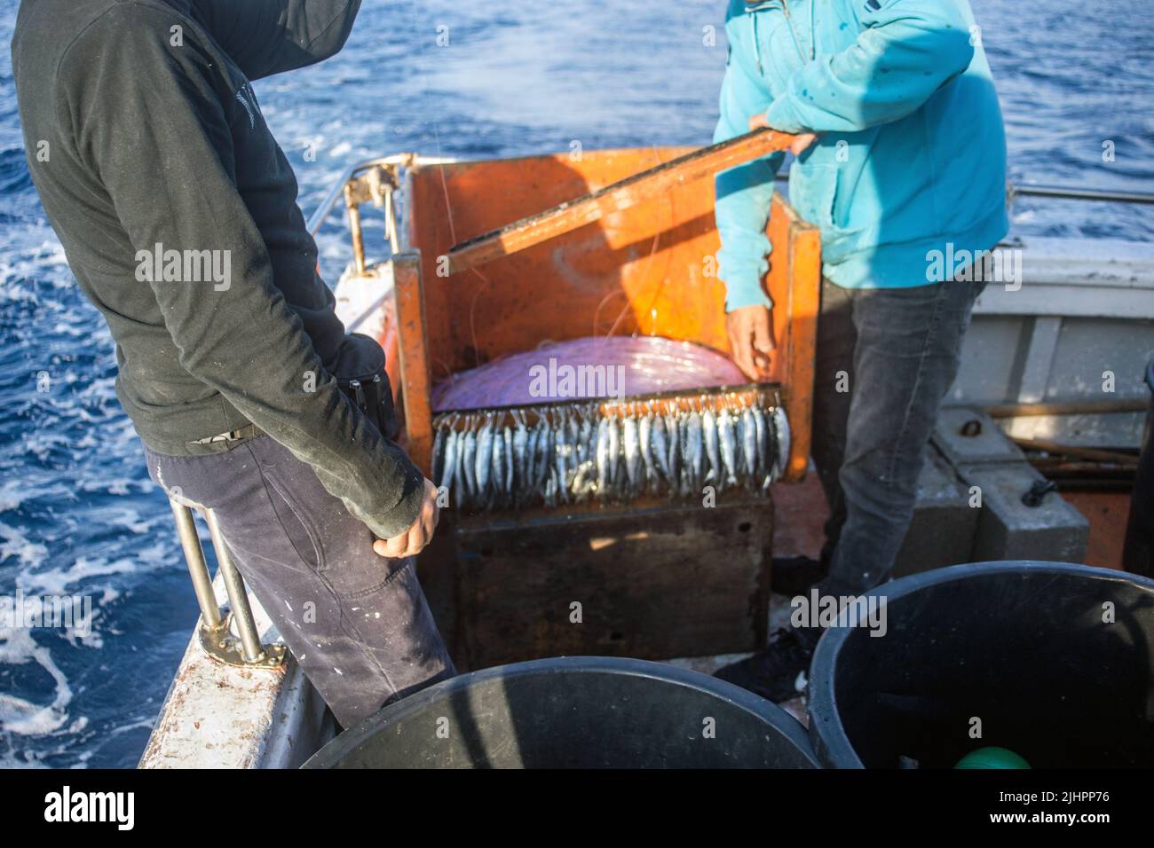 Fishermen pulling the line with hooks and buoys Stock Photo - Alamy