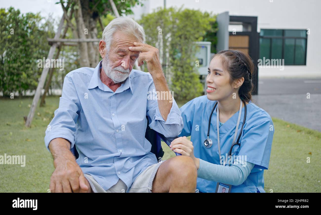 Depressed male patient crying on wheelchair. young nurse caregiver ...