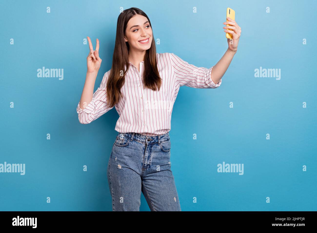 Portrait of beautiful trendy cheerful girl using device taking selfie ...