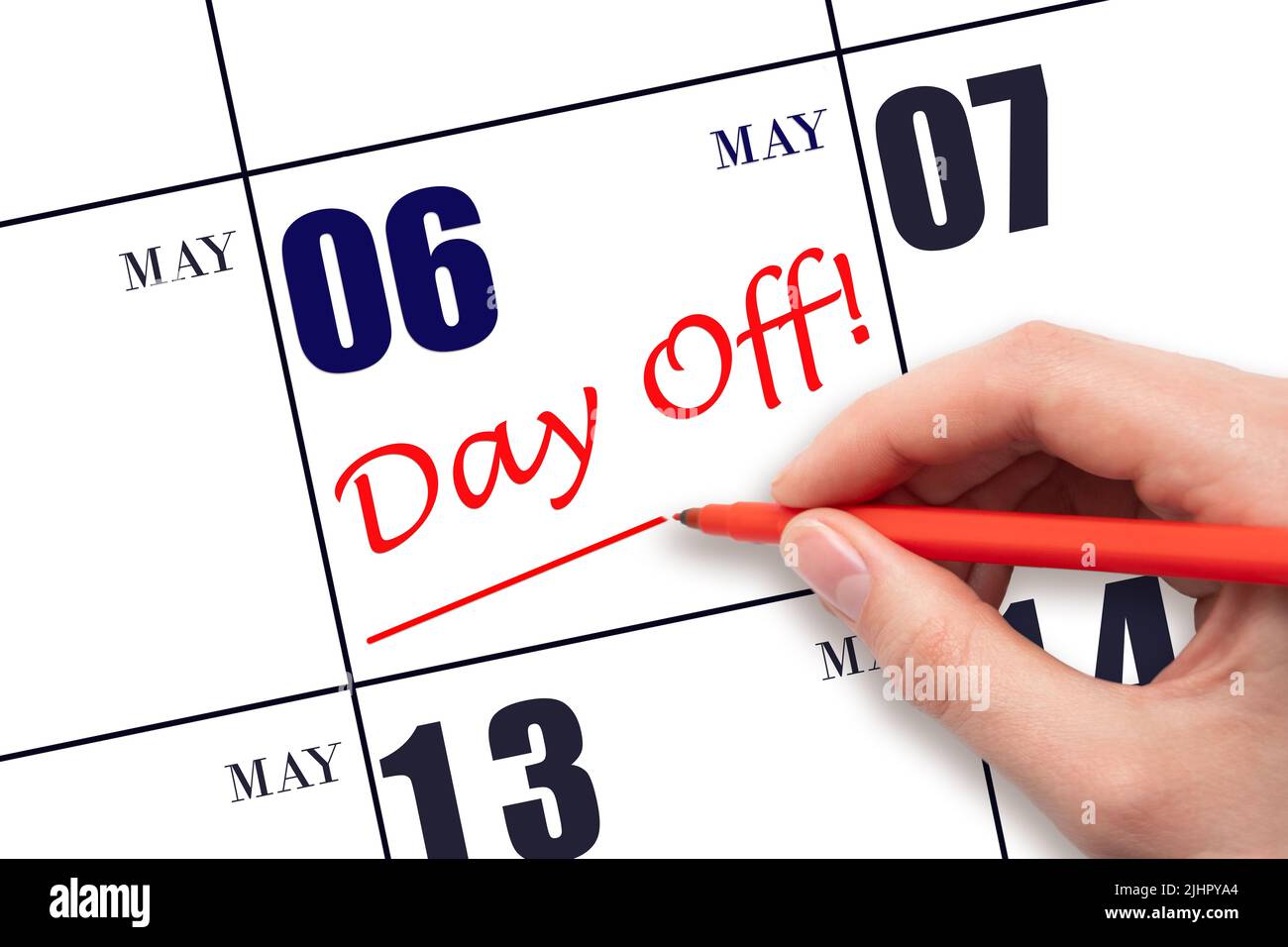 6th day of May. Hand writing text DAY OFF and drawing a line on ...