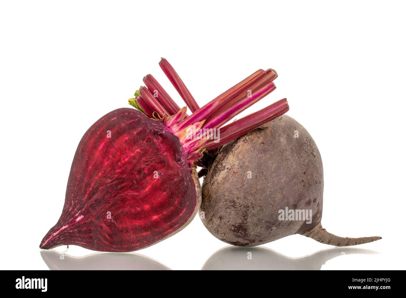 One half and one whole red beetroot, close-up, isolated on white ...
