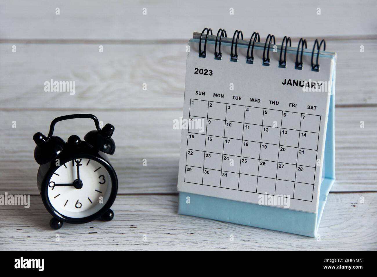 January 2023 white desk calendar with black alarm clock pointing at 9 o ...