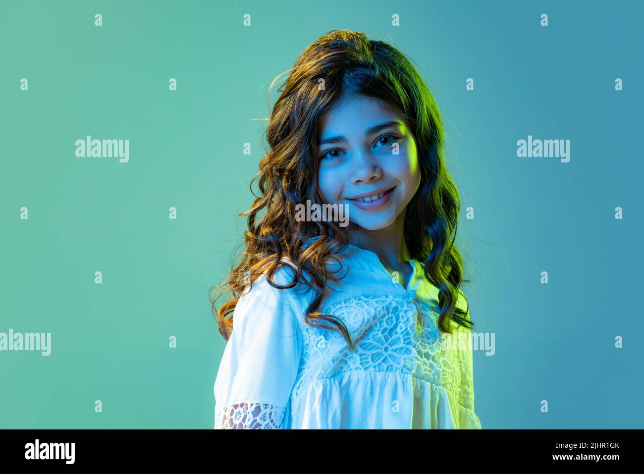 Charming little girl, kid in casual style clothes isolated over cyan ...