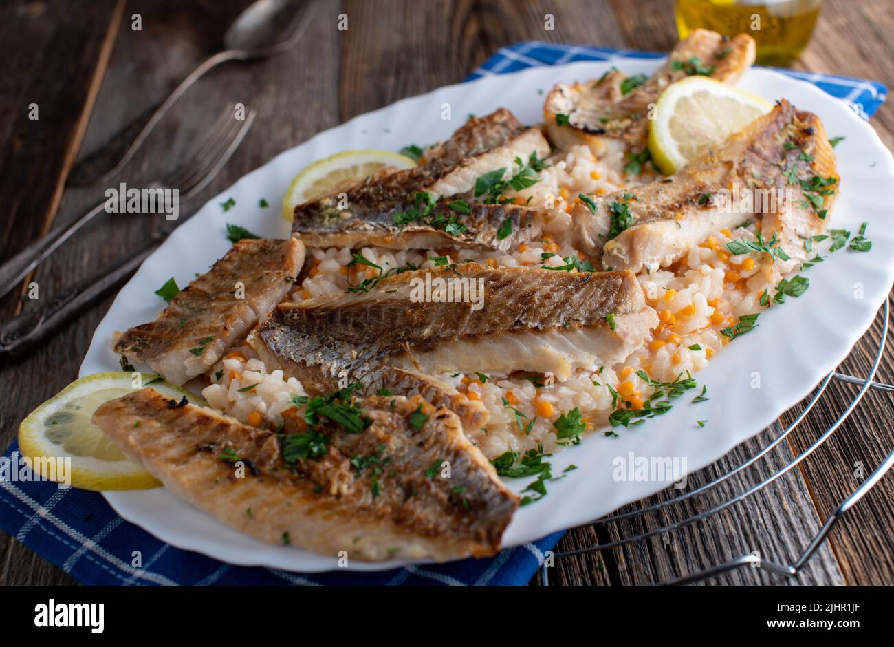 Sauteed fish with red lentil risotto Stock Photo - Alamy