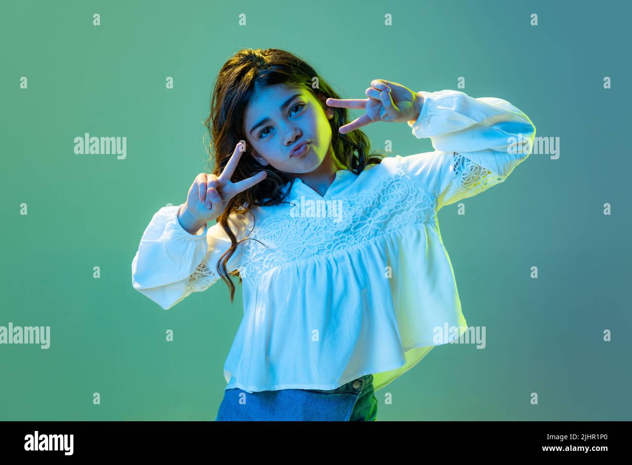 Charming little girl, kid in casual style clothes isolated over cyan ...