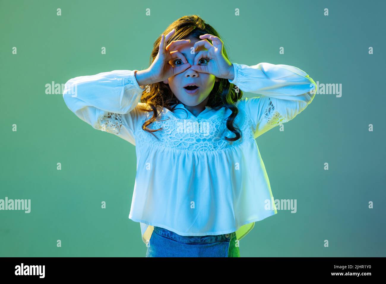 Charming little girl, kid in casual style clothes isolated over cyan ...