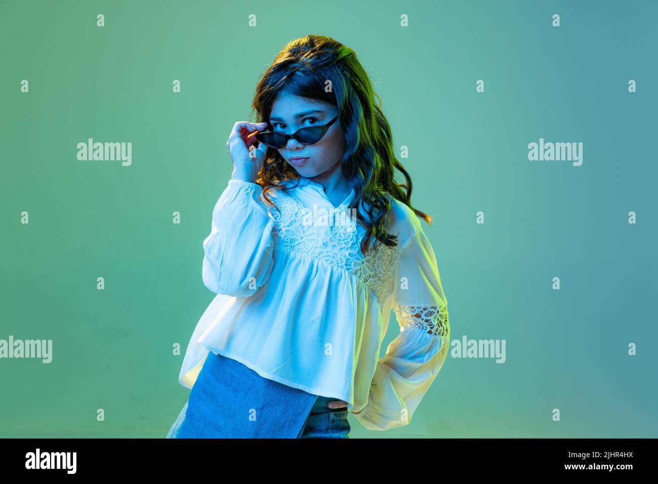 Charming little girl, kid in casual style clothes isolated over cyan ...